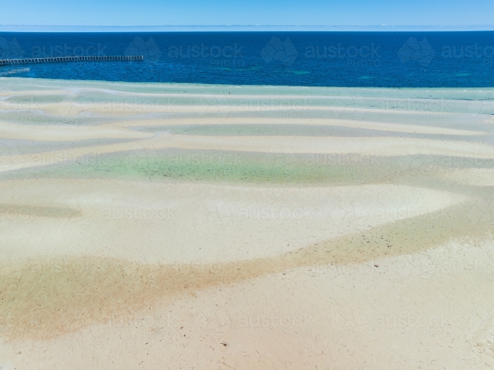 Image of Aerial view of white sand beach with pools of water in front ...