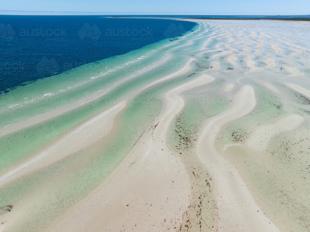 Image of Aerial view of white sand beach with ripples and pools of ...