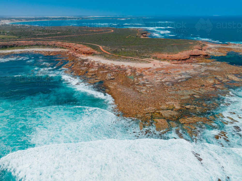 Image of Aerial view of white waves on a blue ocean washing over a ...