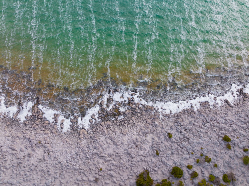 Image of Aerial view of wind blown water on the crusty edge of a salt ...