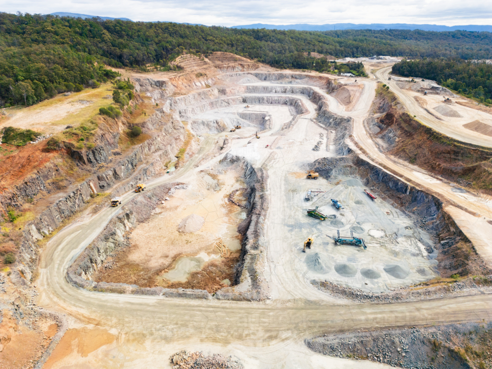 Image of Aerial view over a quarry pit with machinery haulage roads ...