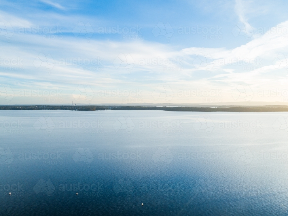 Image of Aerial view over calm blue coastal lake waters - Austockphoto