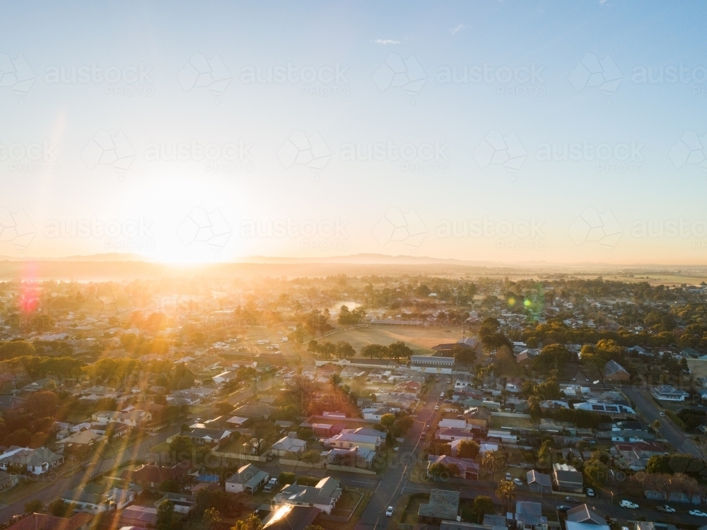 Image of Aerial view over country town with mist on horizon sun rays ...