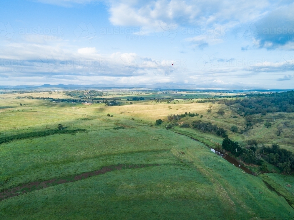 Image of Aerial view over green land of farm paddocks in morning light ...