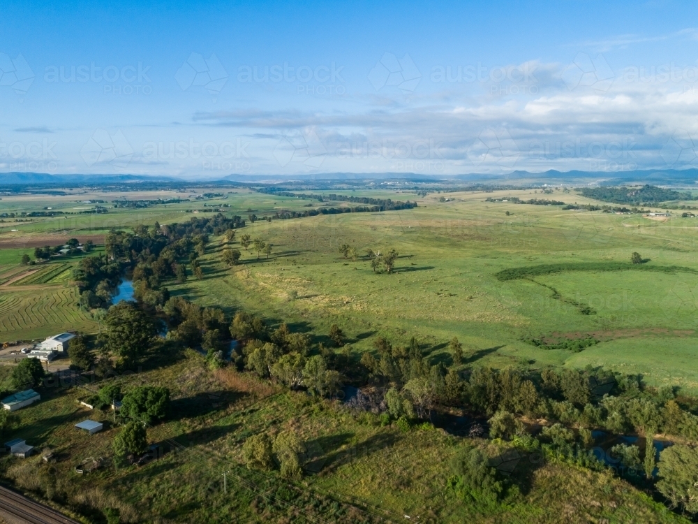 Image of Aerial view over green land of farm paddocks in morning light ...