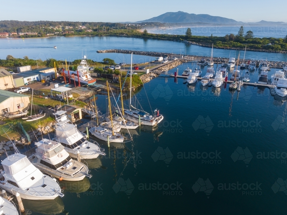 Image of Aerial view over rows of boats moored along a jetty in a ...