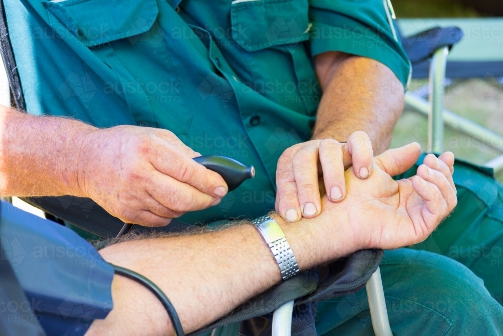 Image of Ambulance officer checking pulse or blood pressure of patient ...