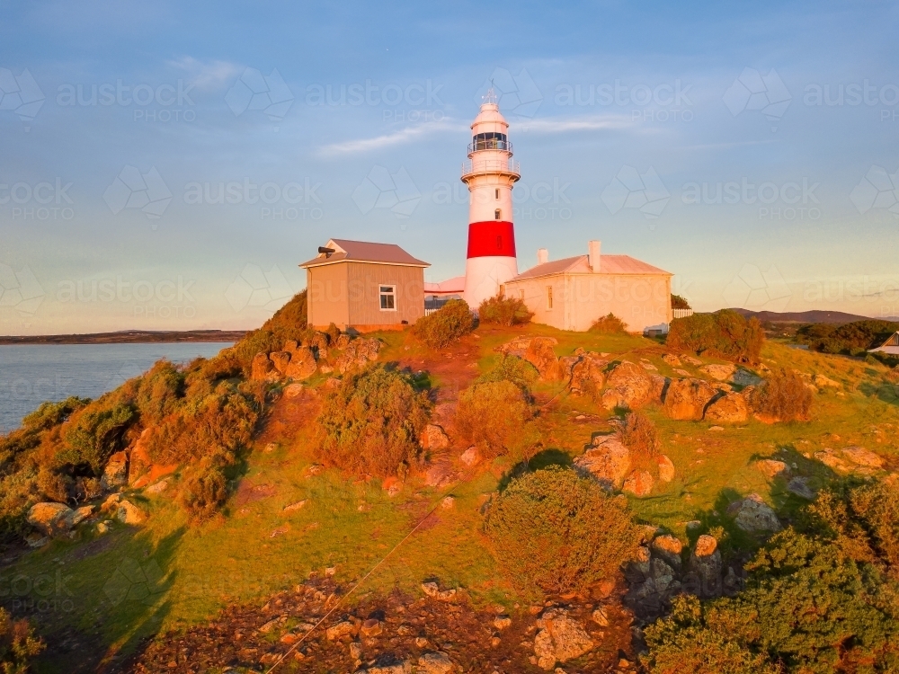 Image of An aerial view of a lighthouse sitting on the top of a cliff ...