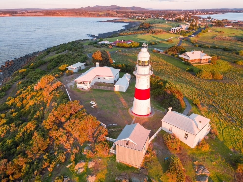 Image of An aerial view of a lighthouse sitting on the top of a cliff ...