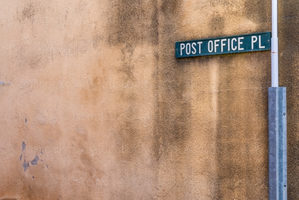 Image of An coloured street sign attached to an discoloured wall of a ...