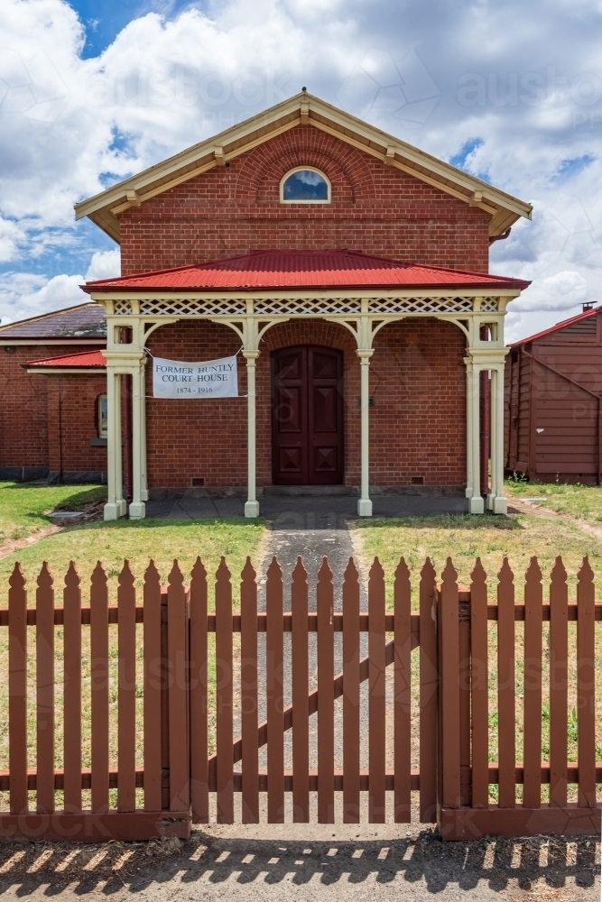 Image of An historic country courthouse with a picket fence and gate ...