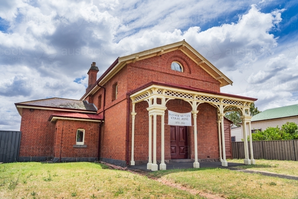 Image of An historic rural courthouse under a dramatic sky - Austockphoto
