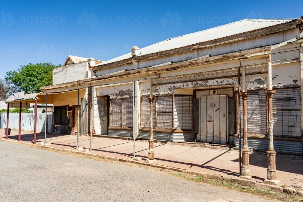 Image of An old abandoned shop with bars over the windows and missing ...