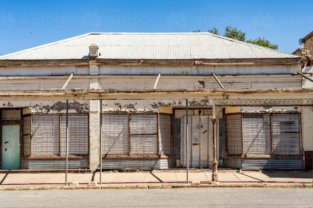 Image of An old abandoned shop with bars over the windows - Austockphoto