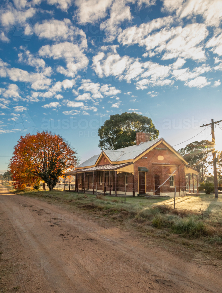 Image of An old brick railway building with an autumn tree - Austockphoto