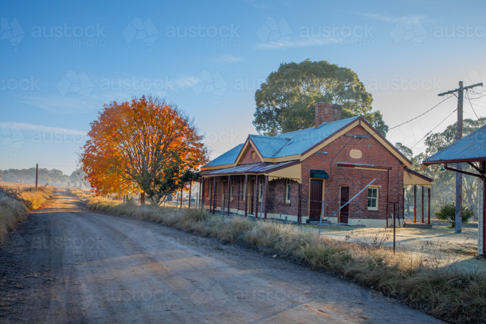 Image of An old country brick building, an autumn tree and a blue sky ...