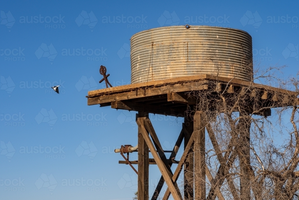 Image of An old rusty water tank on top of a high platform with a ...