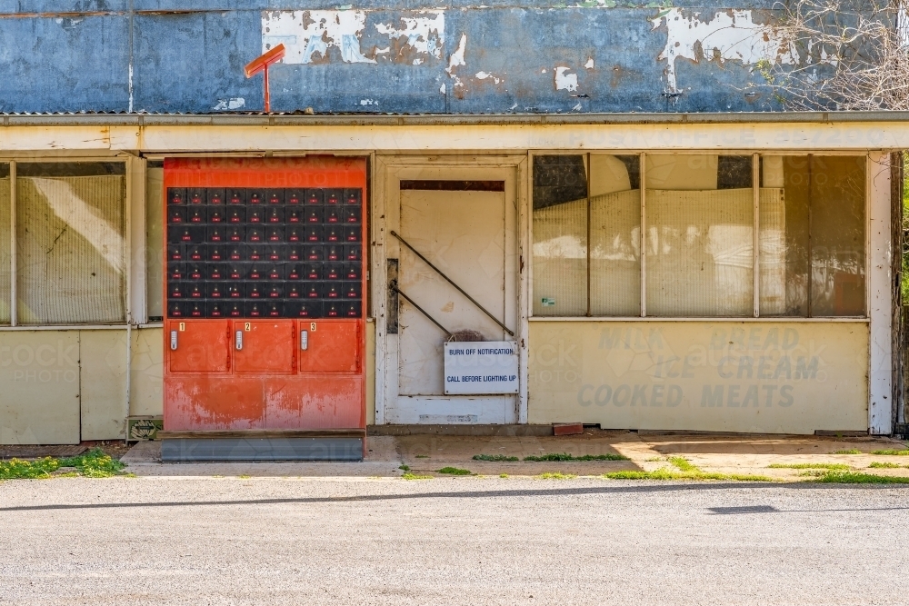 Image of An old shop front with boarded up windows and post office ...