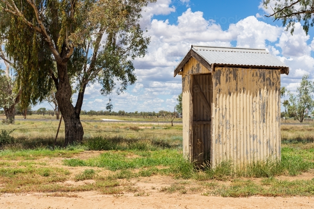 Image of An outdoor corrugated iron dunny sitting in a yard - Austockphoto