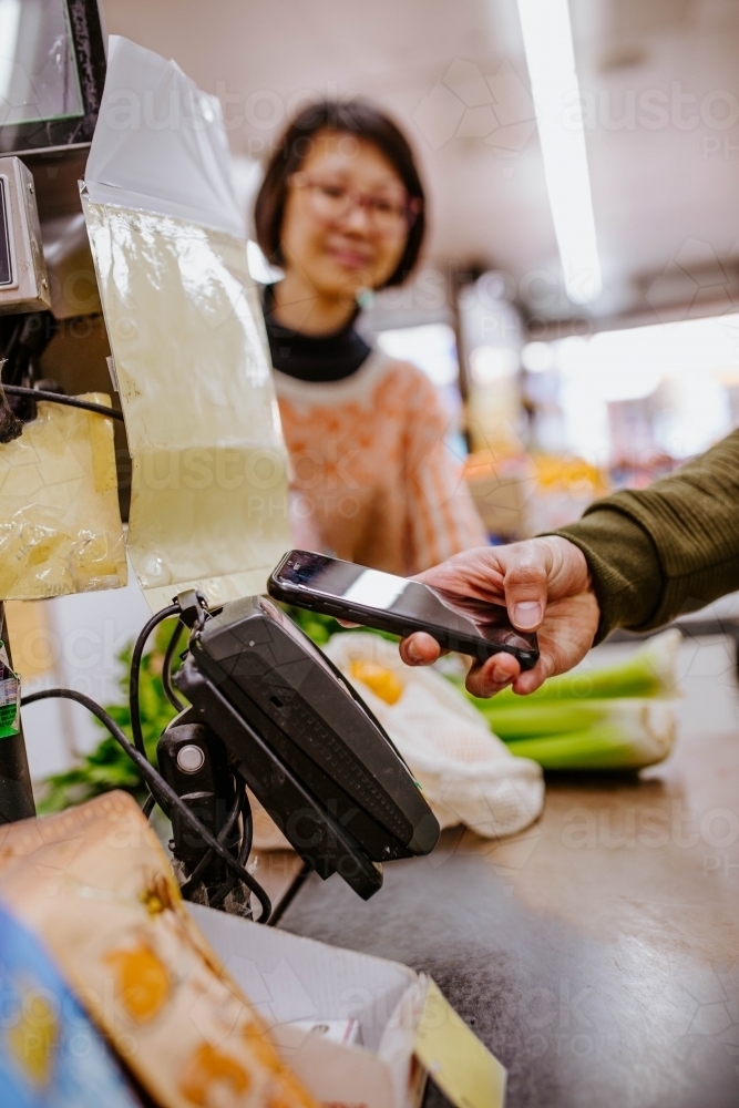 Image of Arm of man paying by card at supermarket counter - Austockphoto