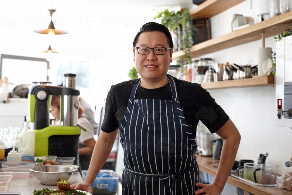 Image of Asian chef working in kitchen at organic food cafe - Austockphoto