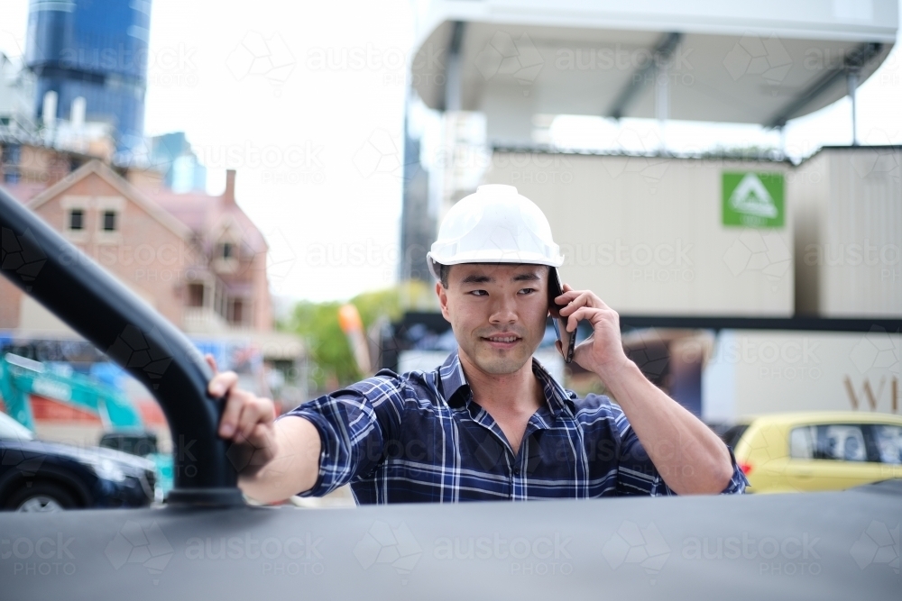 Image of Asian man at work on a call - Austockphoto