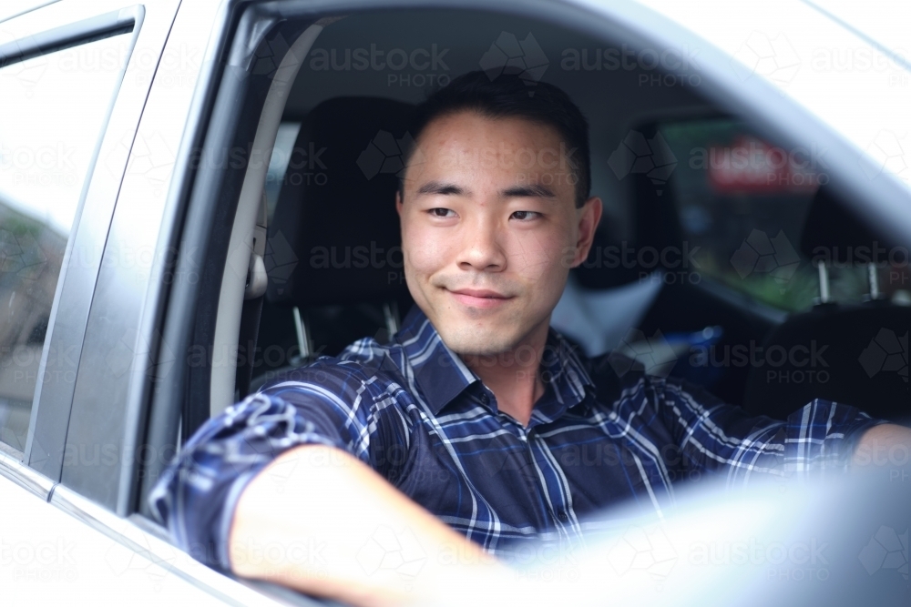 Image of Asian man in driver's seat of car - Austockphoto
