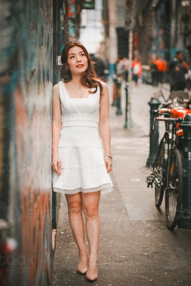 Image of Asian woman leaning against wall in Hosier Lane, iconic ...