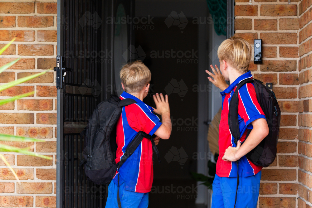 Image of Aussie boys with bags waving goodbye at door of home ready for ...