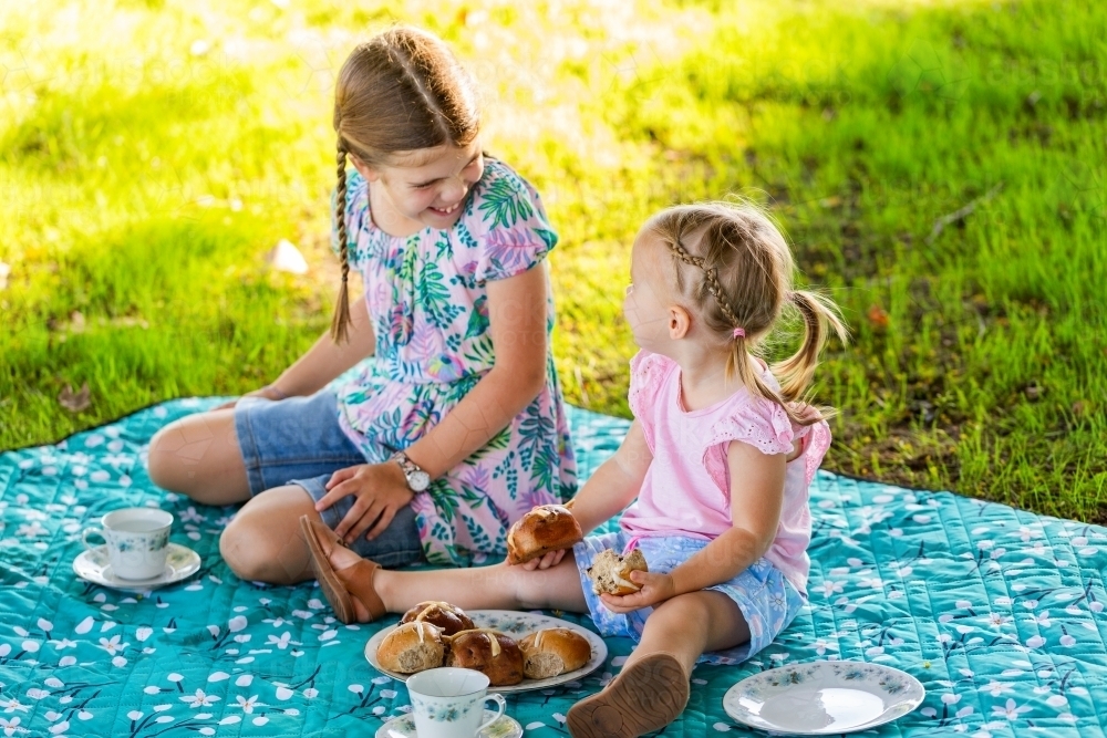 Image of Aussie kids at easter time eating hot cross buns at park ...