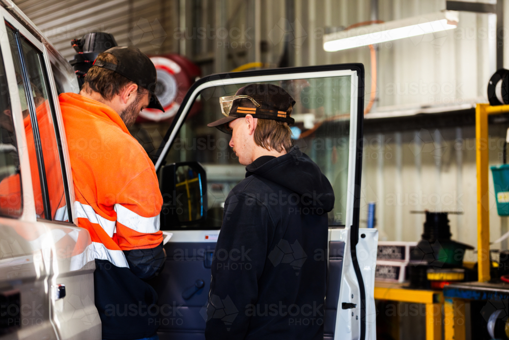 Image of Aussie mechanics standing at open drivers side door of a ...