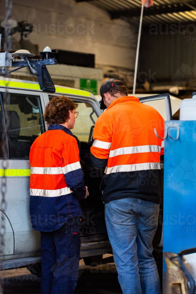 Image of Aussie mechanics standing beside a vehicle in industrial ...