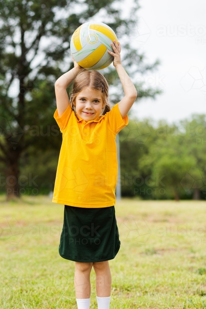 Image of Aussie school girl throwing ball during sports game outside ...