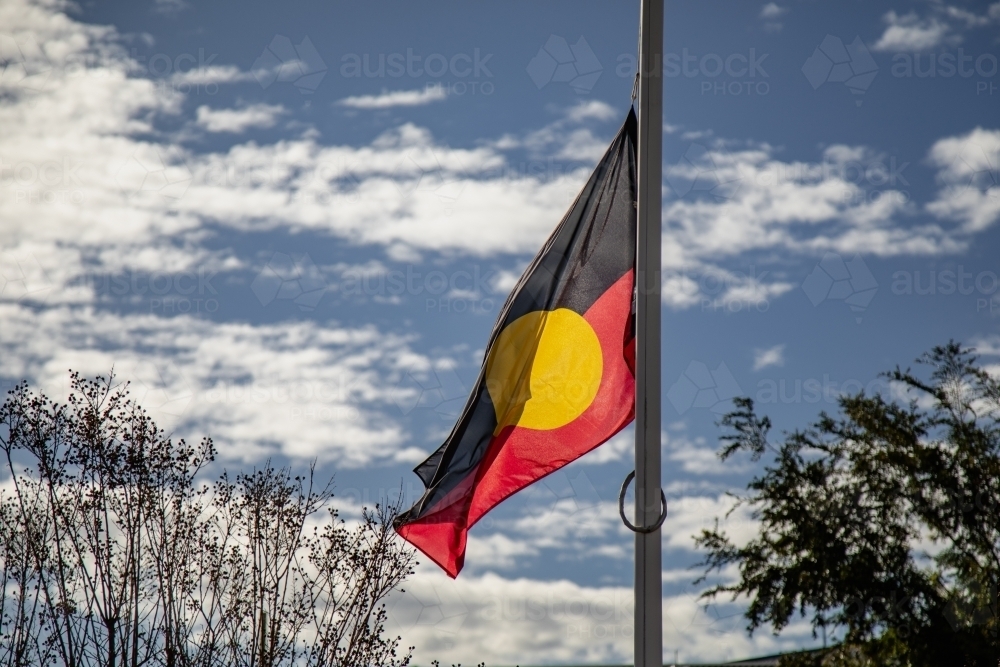 Image of Australian Aboriginal flag flying in the wind with blue sky ...