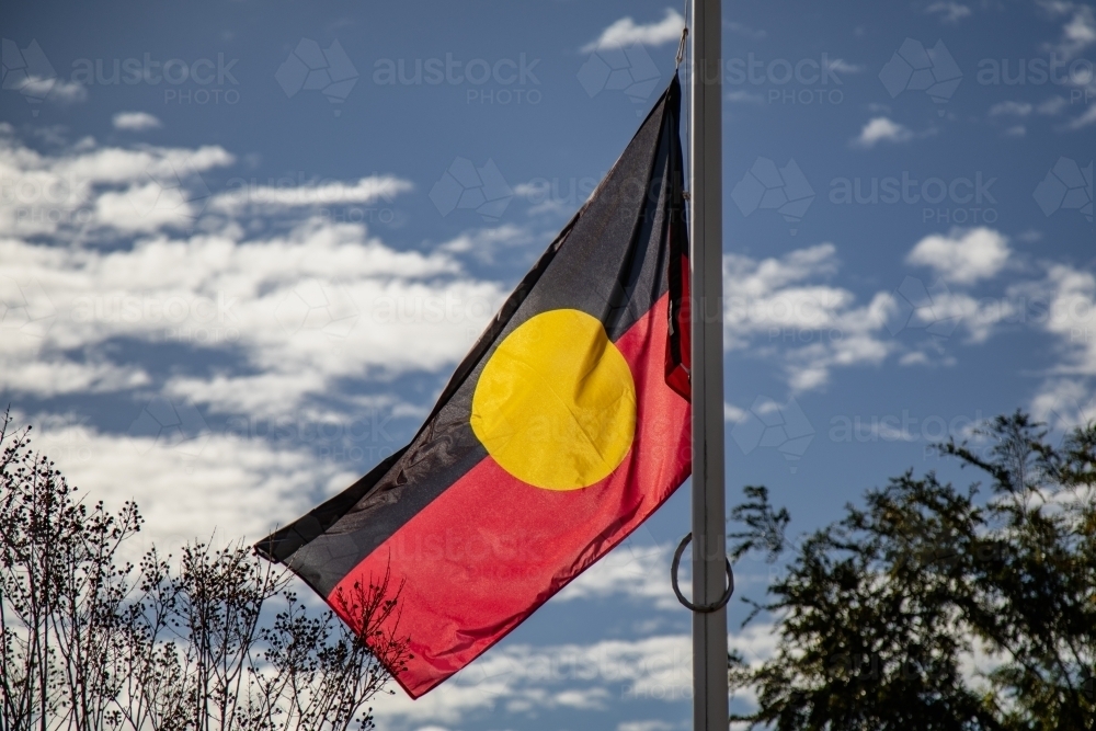 Image of Australian Aboriginal flag flying in the wind with blue sky ...