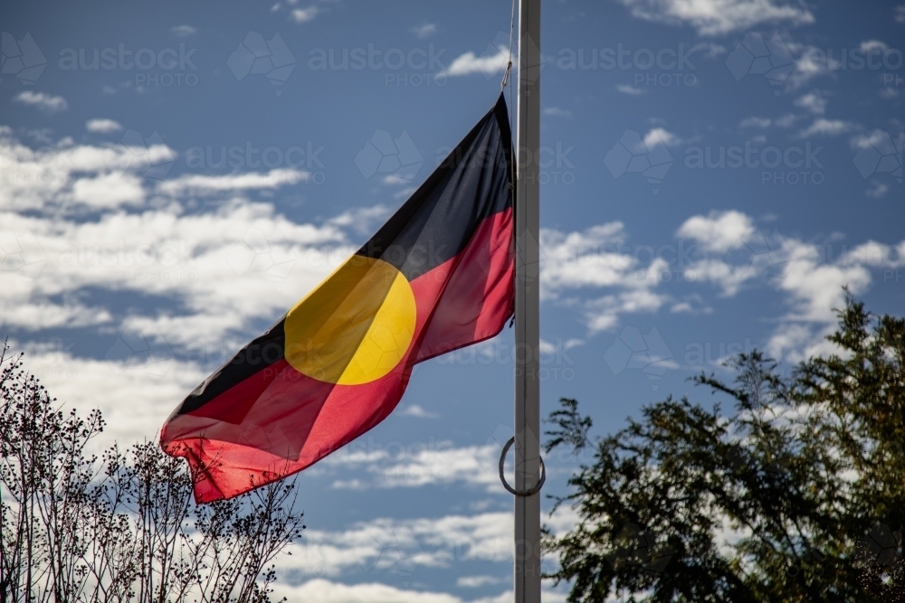 Image of Australian Aboriginal flag flying in the wind with blue sky ...