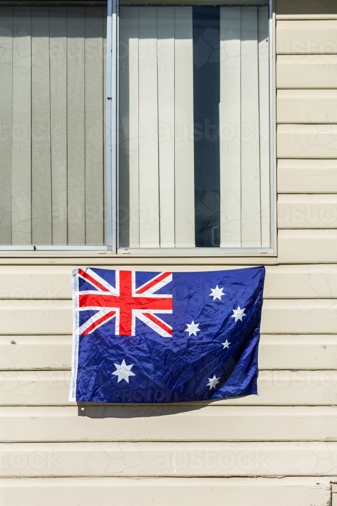 Image of Australian flag on wall of sunlit weatherboard house ...
