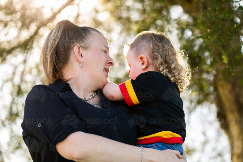 Image of Australian mum holding sad boy with scraped skin on elbow ...