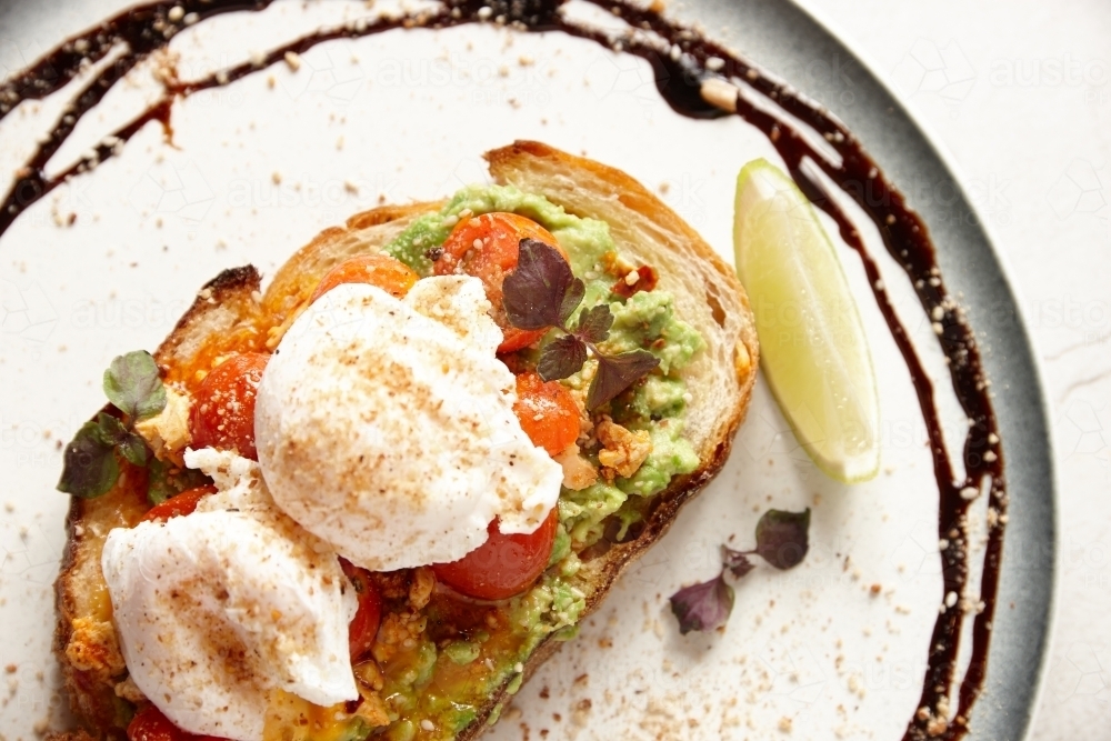 Image of avocado toast with tomatoes and white cheese on top - Austockphoto