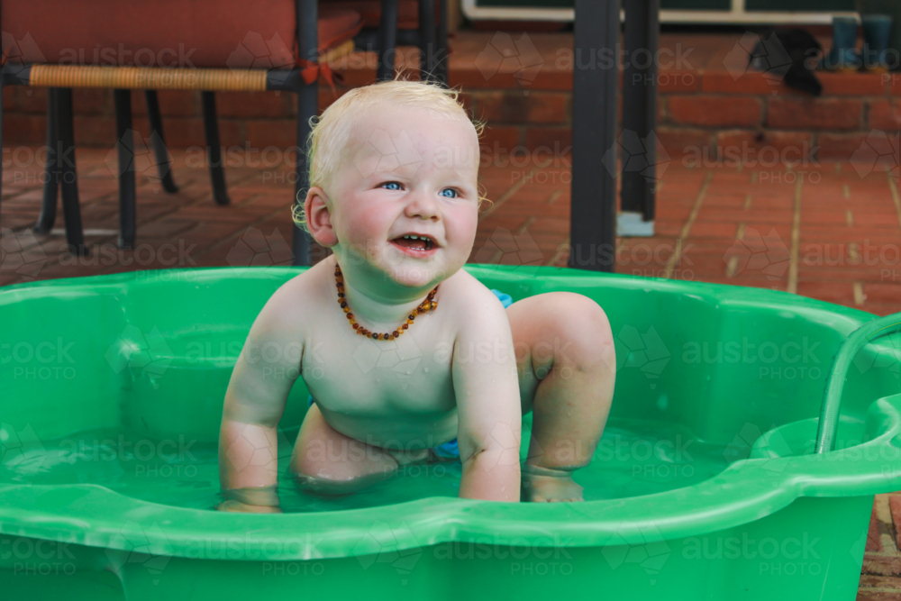 Image of Baby boy playing in green plastic shell pool in summer ...