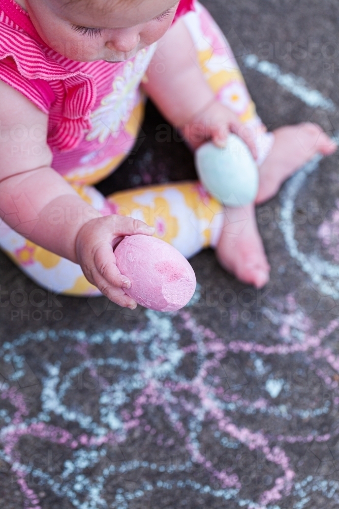 Image of Baby drawing with chalk on concrete - childhood - Austockphoto