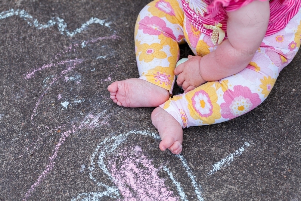 Image of Baby drawing with chalk on concrete - childhood - Austockphoto