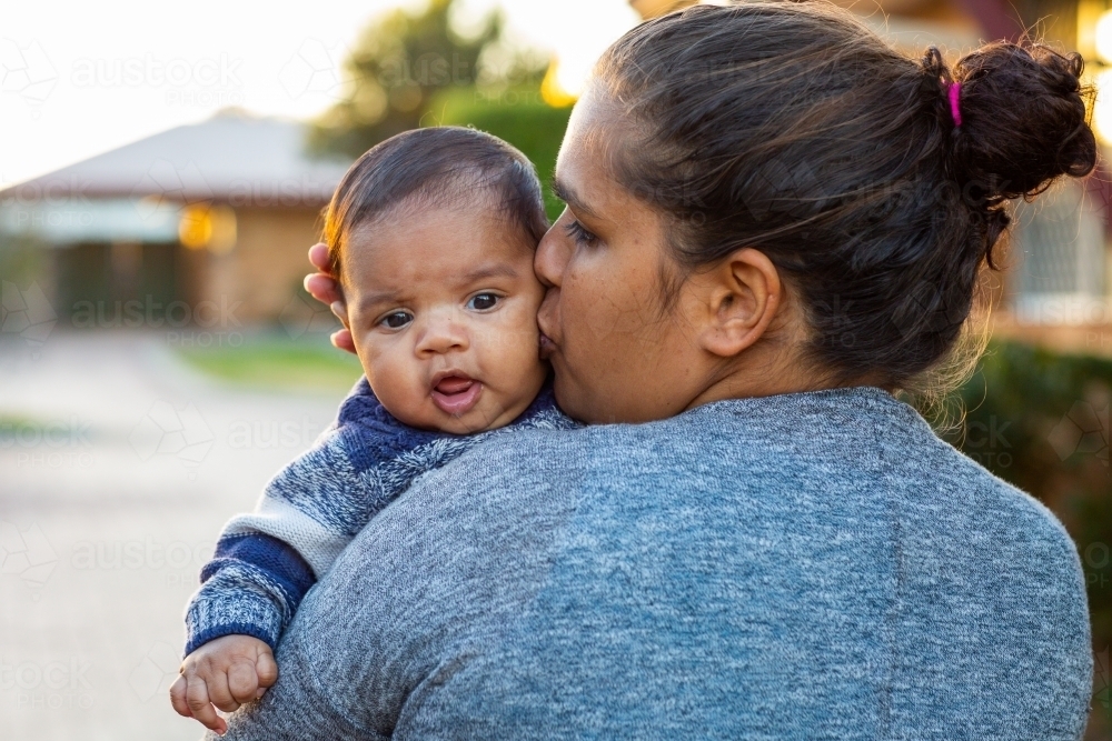 Image of Baby looking over his mother's shoulder - Austockphoto