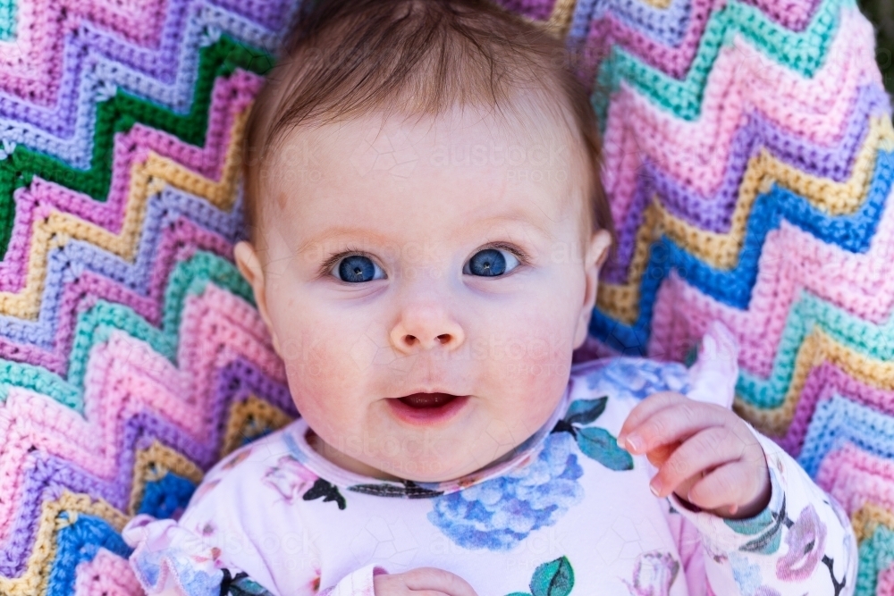 Image of Baby with wide blue eyes and a surprised expression - Austockphoto