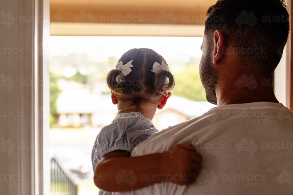 Image of Back profile of father carrying toddler daughter to the ...