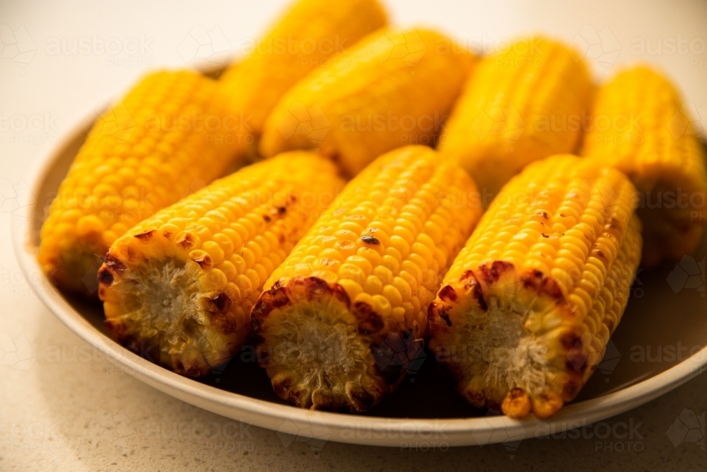Image of barbecued corn cobs on a plate - Austockphoto