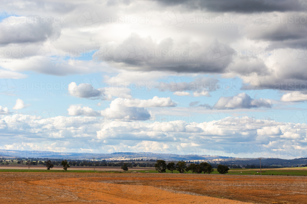 Image of Bare land of farm paddock with red tilled dirt in foreground ...