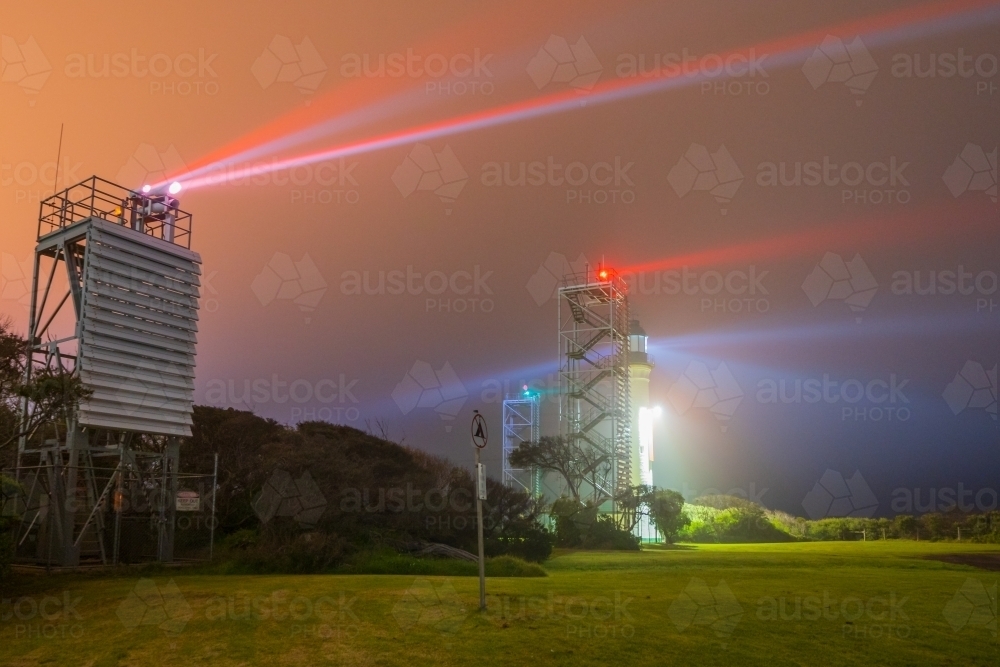 Image of Beams of light from a lighthouse and beacon tower on a dark ...