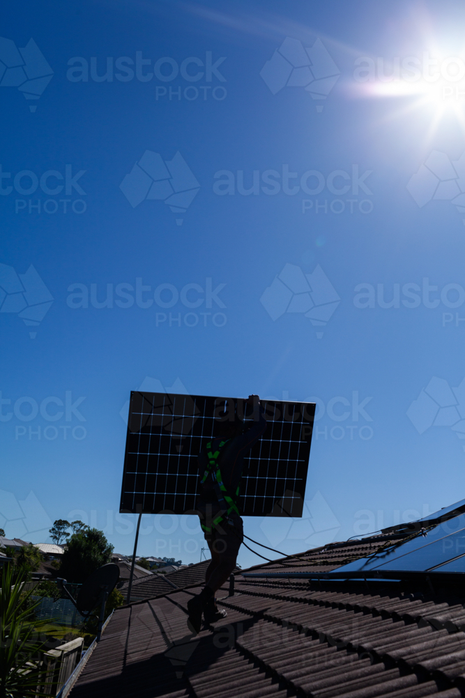 Image of bifacial solar panels being carried on rooftop during solar ...
