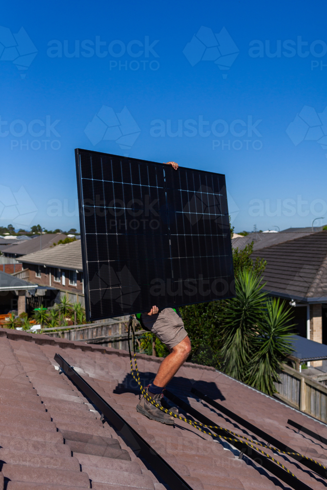 Image of bifacial solar panels being carried on rooftop during solar ...